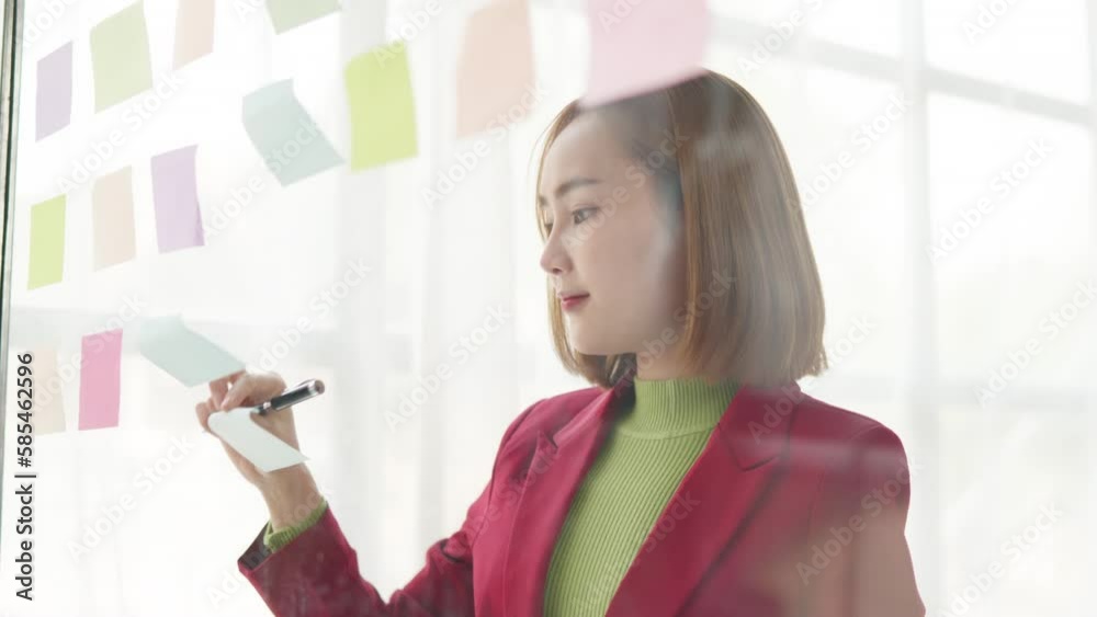 Young business woman in red suit working on sticky notes post it on ...