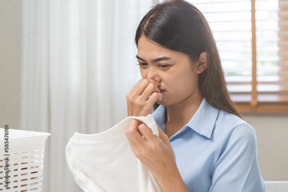 Asian young housewife woman having bad smelling clothes holding breath ...
