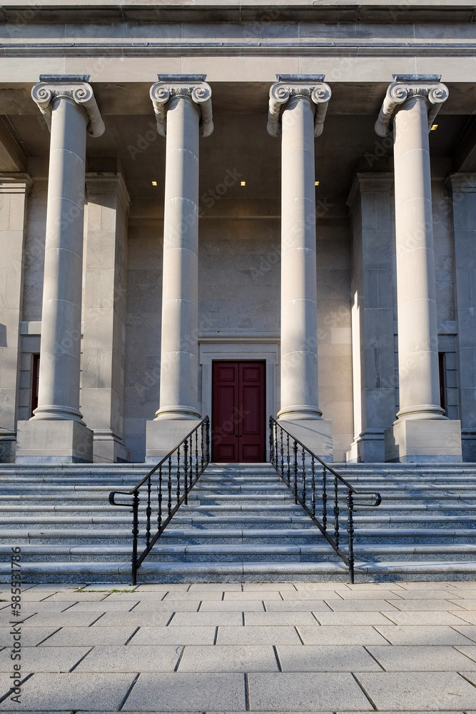 Four large round concrete columns at the top of marble steps with black ...