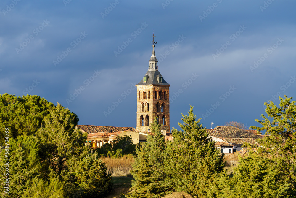 Church tower of the Monasterio el Parral de Segovia between trees with ...