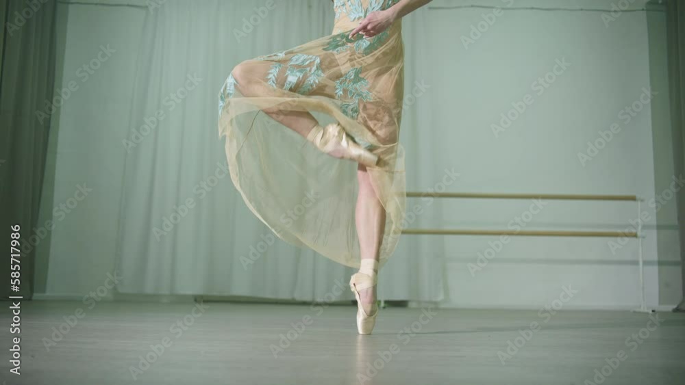 Close-up of the legs of a ballerina dancing in a training hall ...