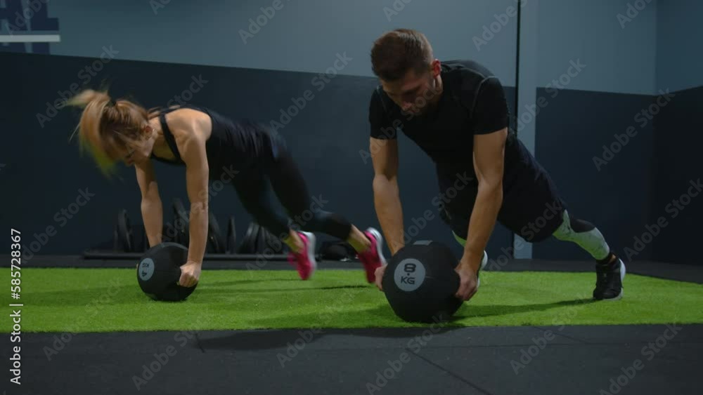 A young couple trains in the gym doing modern exercises to improve ...