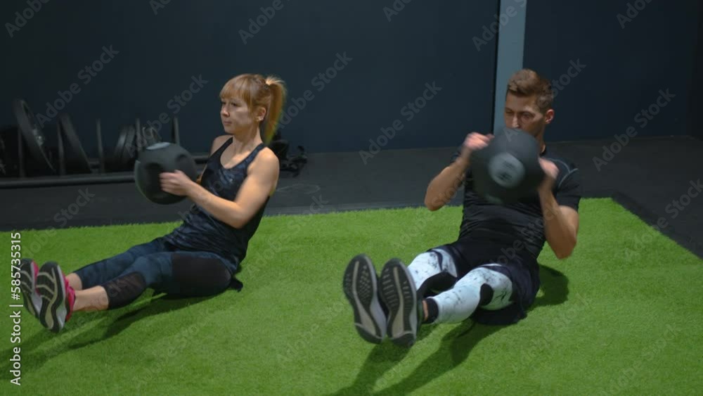 A young couple trains in the gym doing modern exercises to improve ...