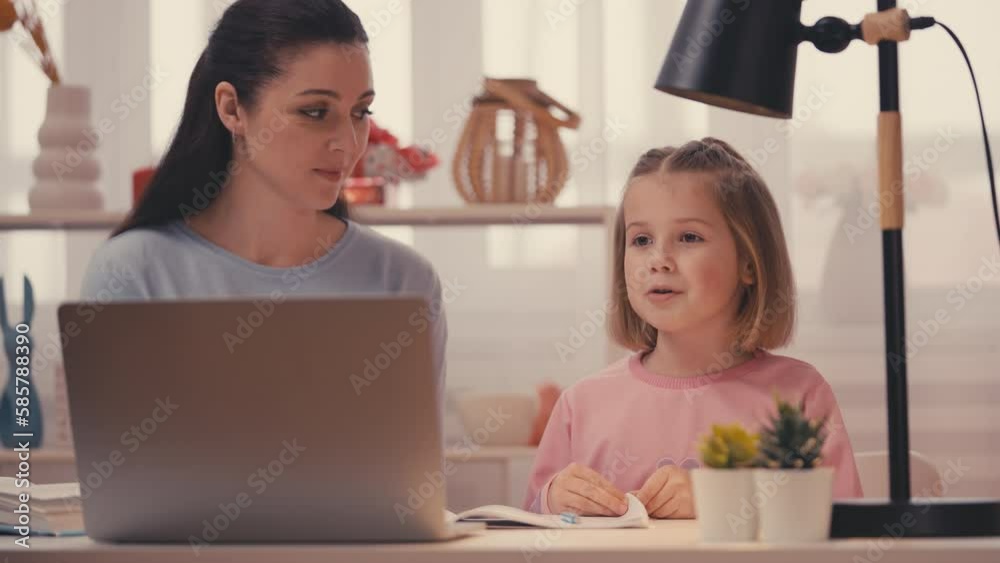 Little girl reciting poem on laptop camera during online video lesson ...