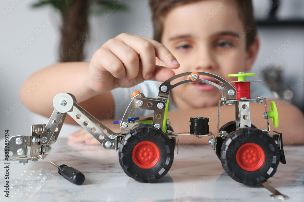 Poster little preteen boy play with steel mechanical constructor set ...