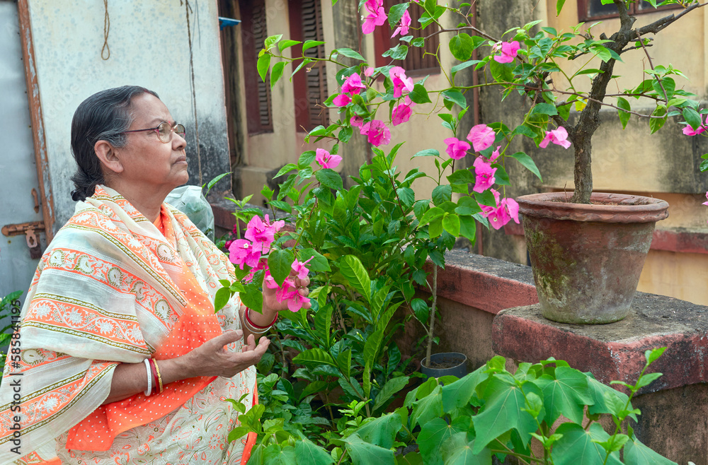 A simple looking, ethnic dressed aged Bengali woman appreciating ...