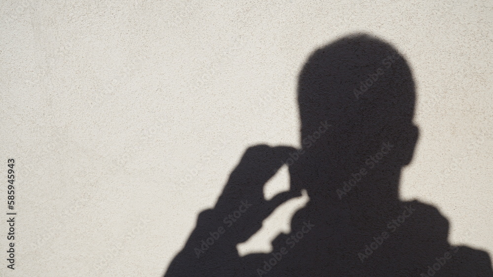 shadow of man talking on the phone projected on white wall Stock Photo ...