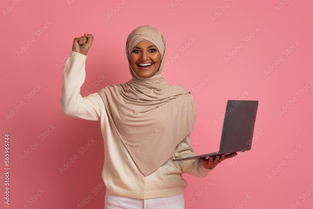 Excited Muslim Woman In Hijab Holding Laptop Computer And Celebrating ...