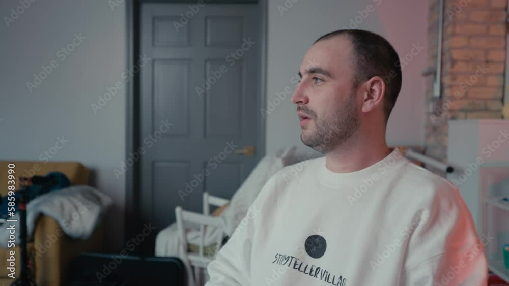 white caucasian male sitting in a chair smiling then adjusting his ...
