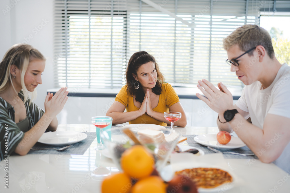 Young family of father with wife and daughter sitting on dining table ...