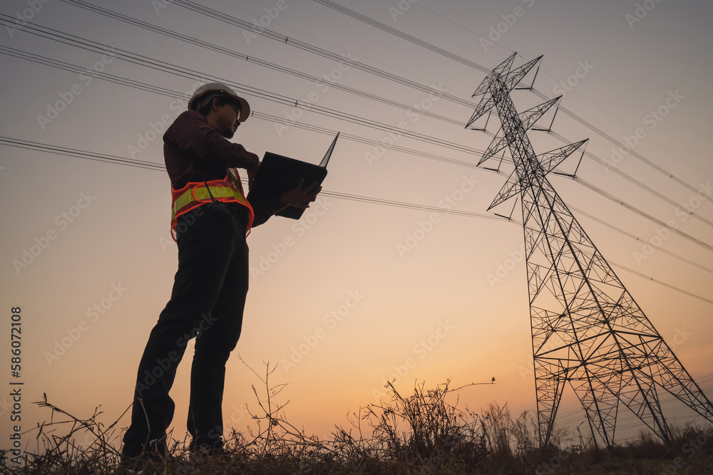 High voltage engineer using laptop computer working near high voltage ...