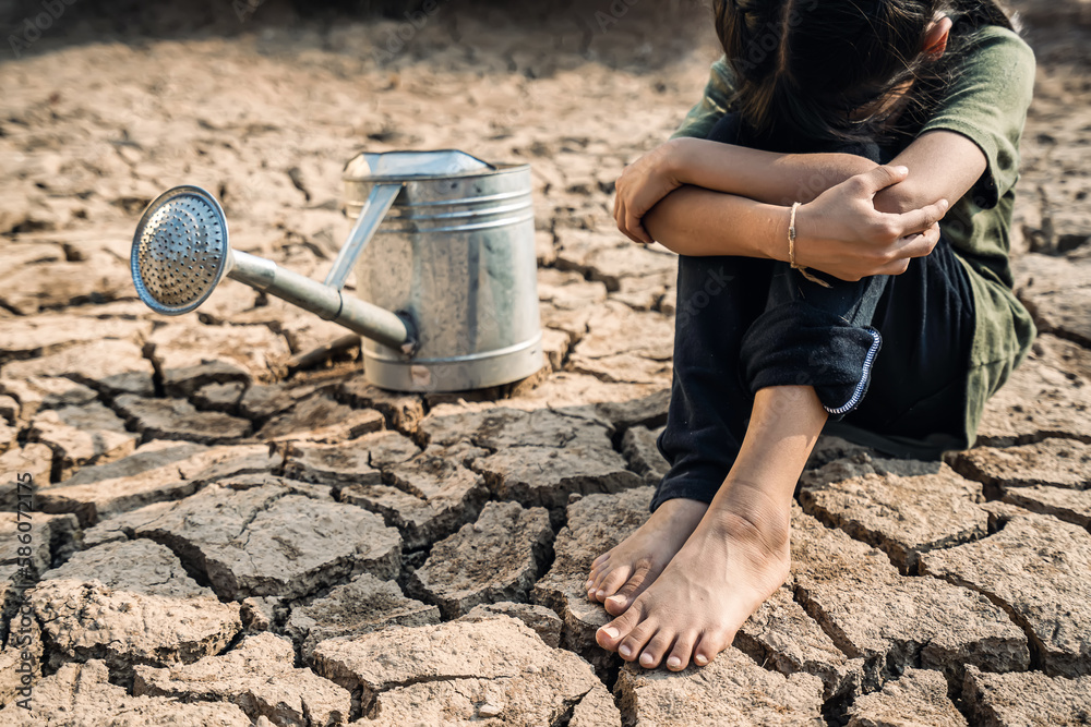 Asian girl sitting sadly in a dry area concept of drought and lack of ...