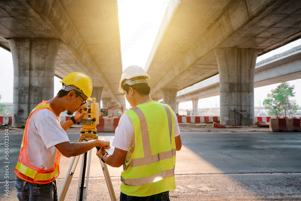 Asian civil engineer team working with theodolite and highway ...