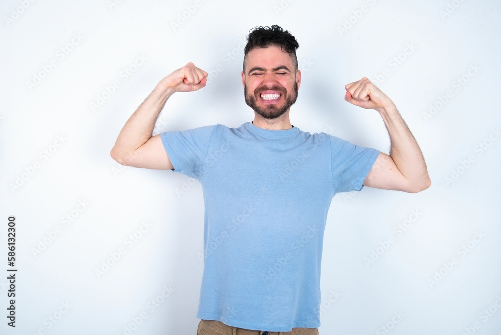 Strong powerful Young caucasian man wearing blue T-shirt over white ...