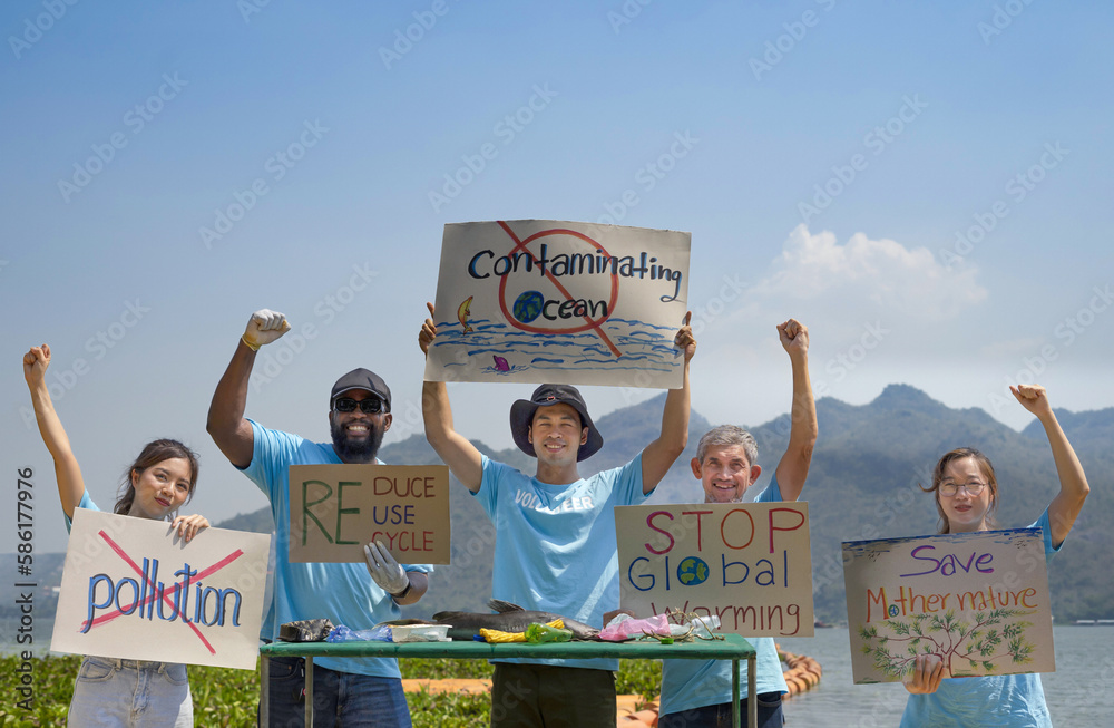 group of volunteers holding environmental campaign signs standing by ...