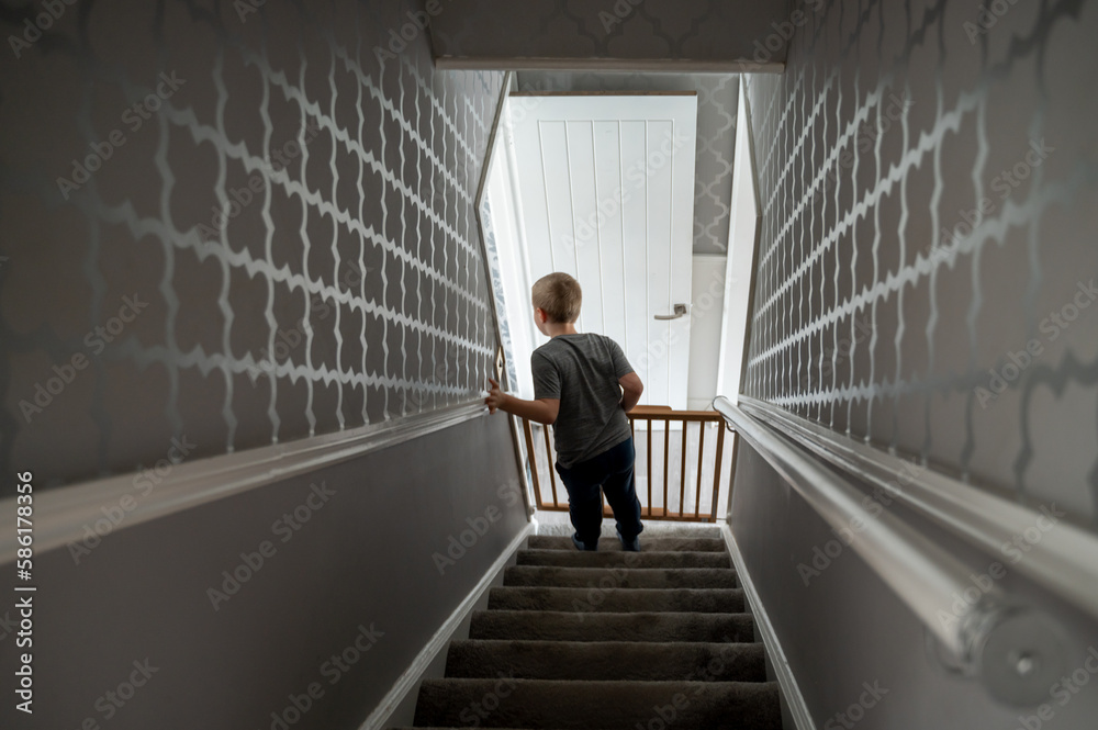 Child going down the steep stairs at home with baby safety gate. Boy in ...