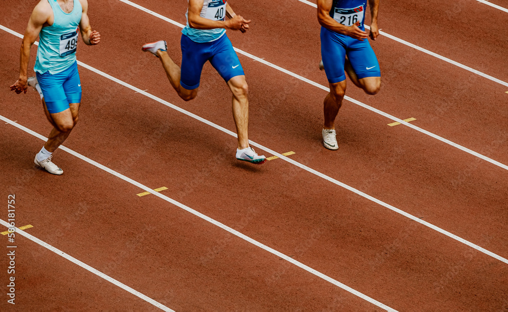 male athletes runners in sprinting spikes Nike run race at stadium ...