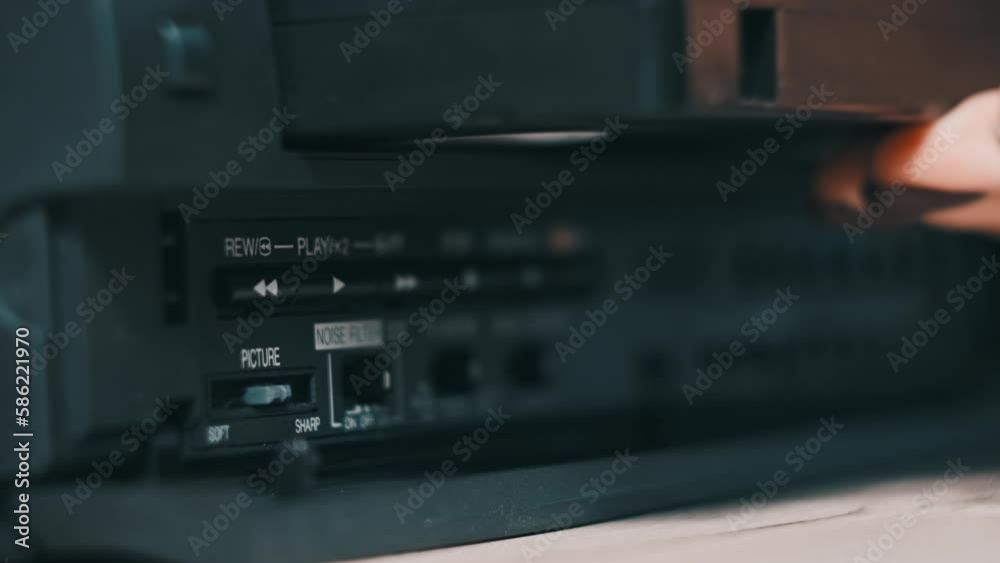 Insert VHS cassette into VCR player. Black vintage videotape cassette ...