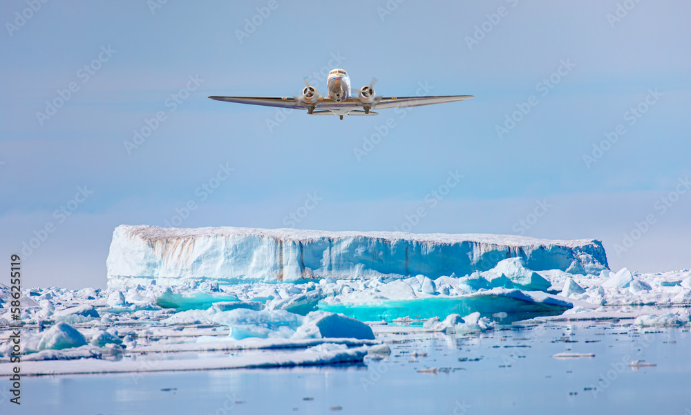 Propeller airliner flying over glaciers - Melting icebergs by the coast ...