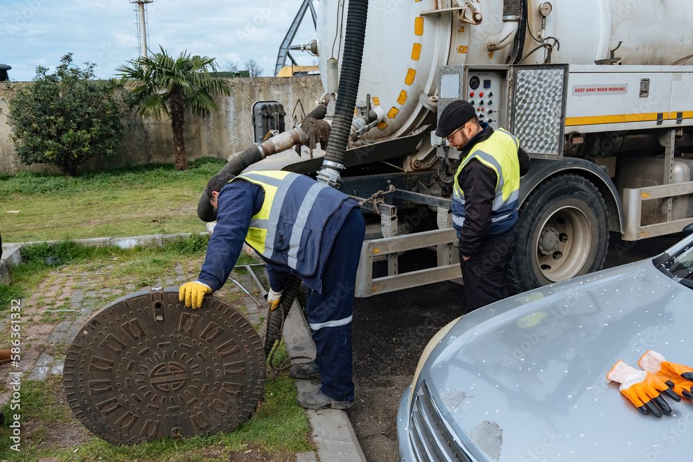 Sewer workers cleaning manhole and unblocking sewers the street ... Sewer workers cleaning manhole and unblocking sewers the street ...