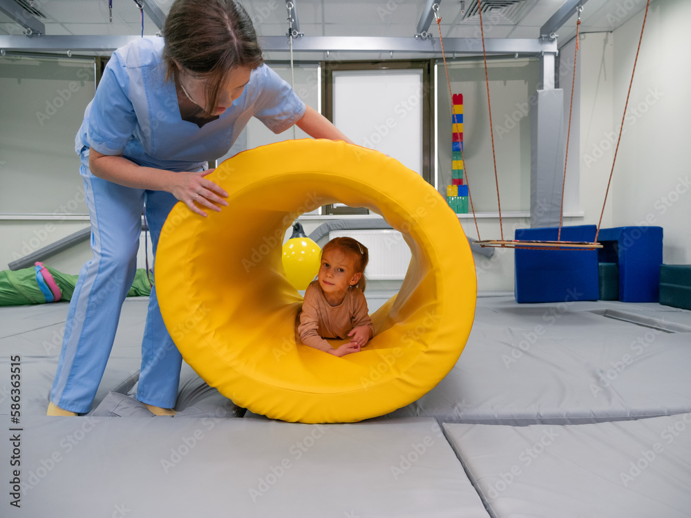 Kid girl rotation in roller tonnel during sensory integration session ...
