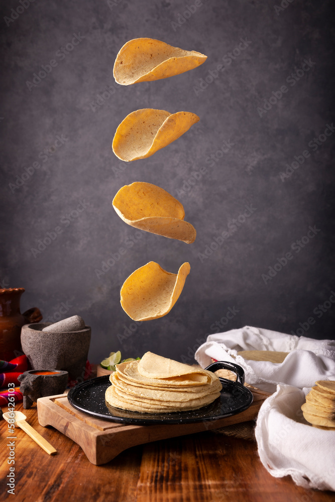 Corn tortillas falling on a Mexican griddle in a typical Mexican ...