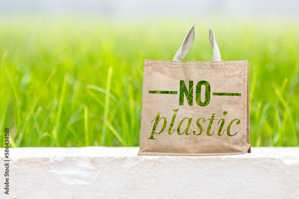 Jute bag with No plastic logo on cement wall over blurred beautiful ...