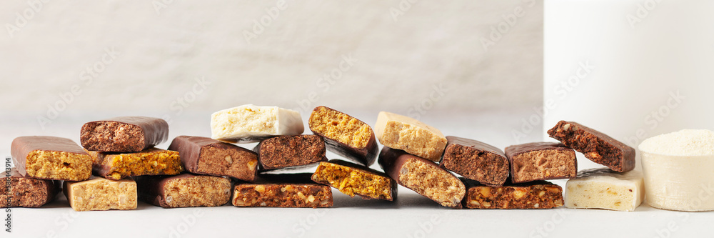 Whey protein powder in measuring scoop and different energy protein bar ...