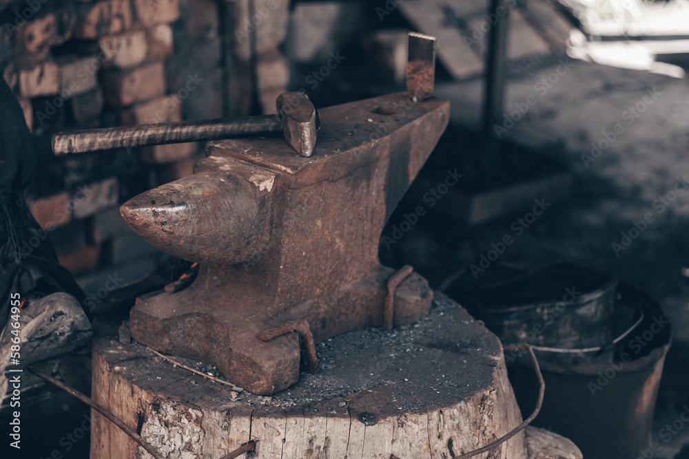 Process metal with hammer on anvil in forge. Strike iron outdoors in ...