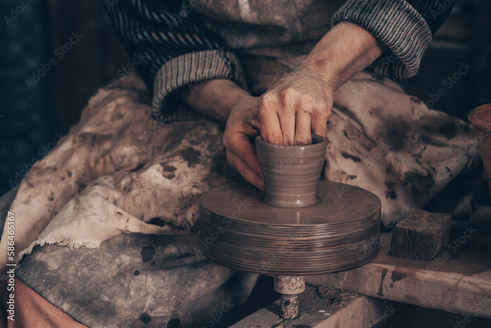 Modeling bowl from clay on wheel in pottery workshop. Dirty hands of ...
