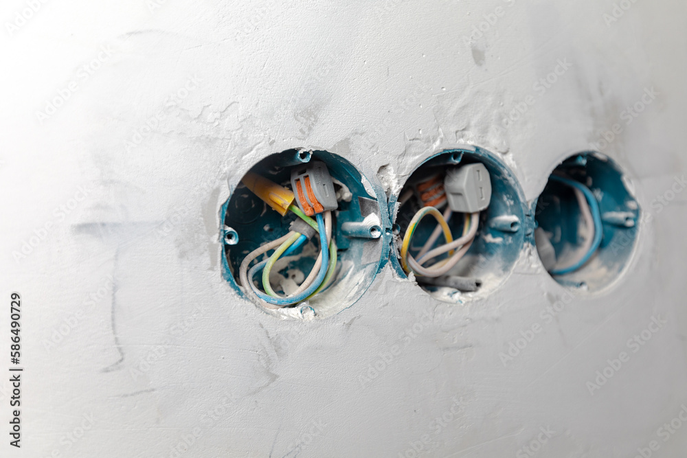 Several round holes for electrical outlets on the primed walls. Wires ...