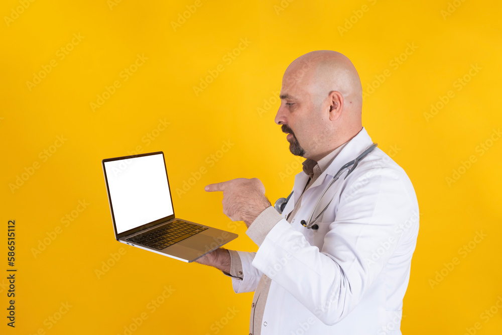 Pointing laptop screen, middle aged bald doctor pointing laptop screen ...