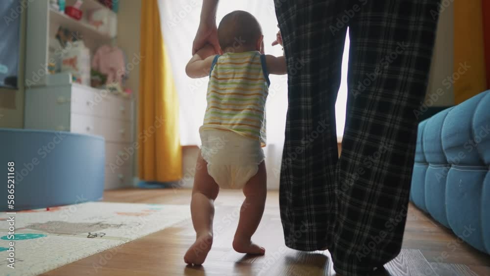baby takes the first steps to learn. happy family kid dream concept ...