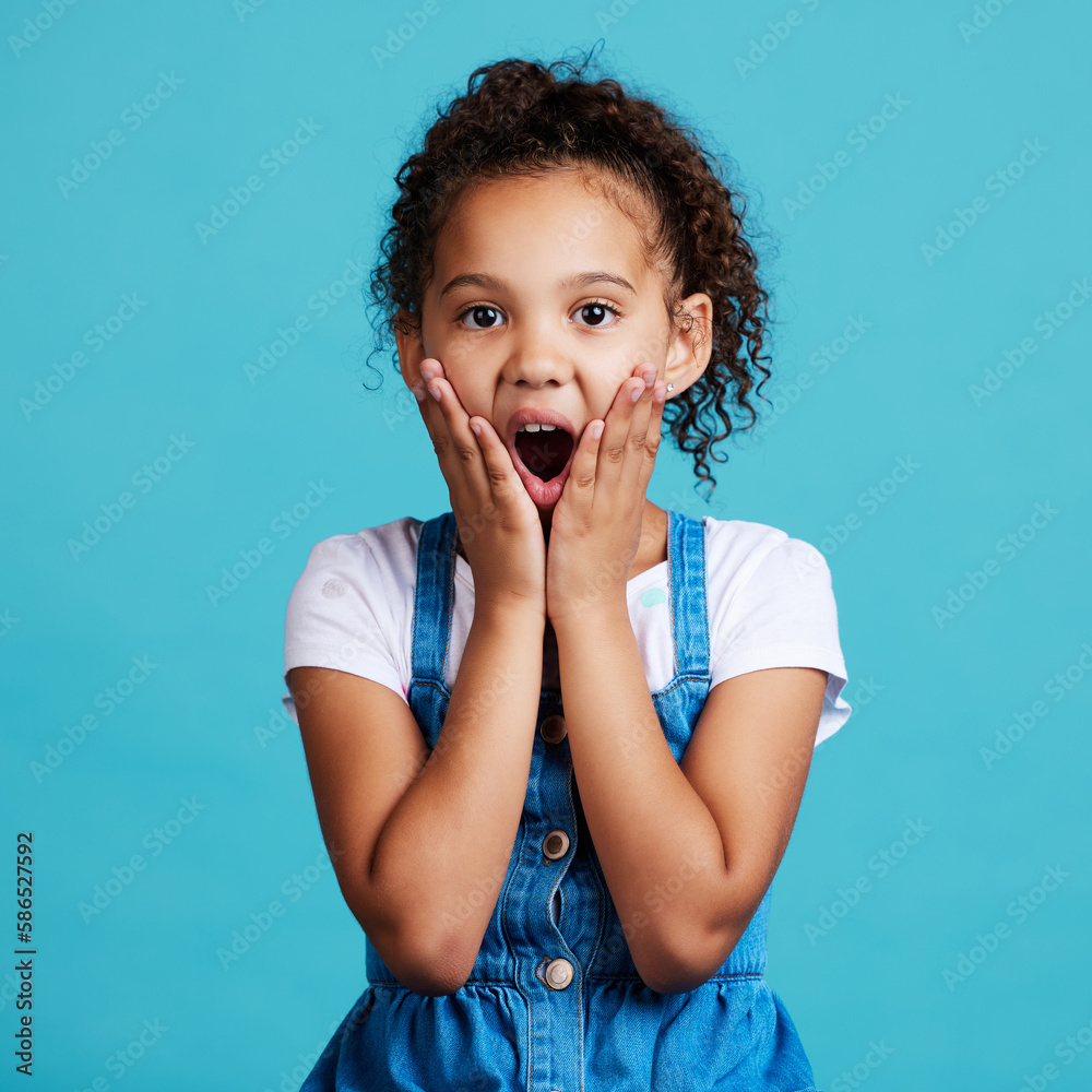 Portrait, surprise and girl with wow, facial expression and happiness against a blue studio ...