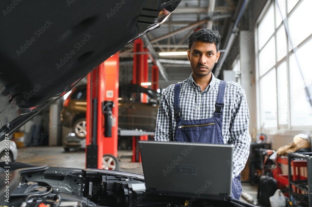 Indian car mechanic standing and working in service station. Car ...