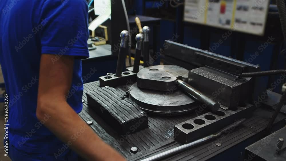 Vidéo Stock Man in overalls approaches factory machine with metal party ...