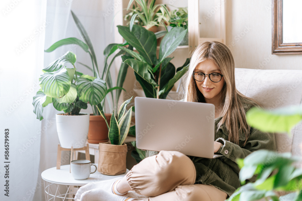 Freelance woman in glasses typing at laptop and working from home ...