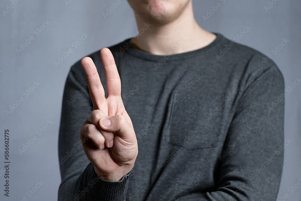 Index and middle finger of hand raised up sign of two young men in ...