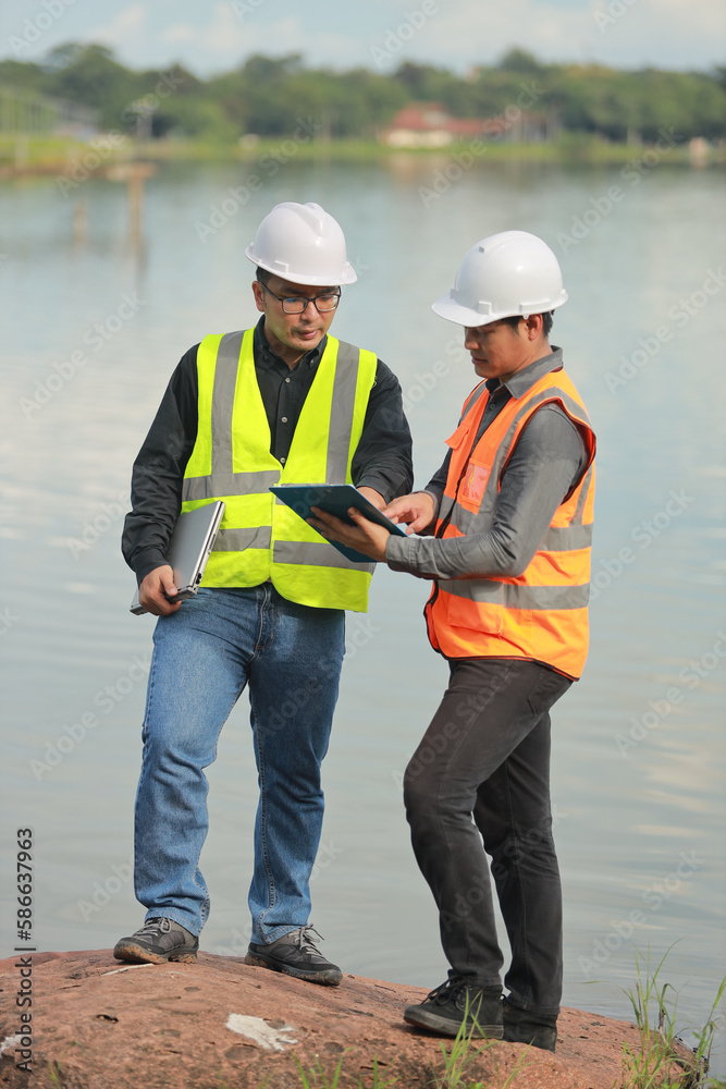 Environmental engineers work at water source to check for contaminants ...