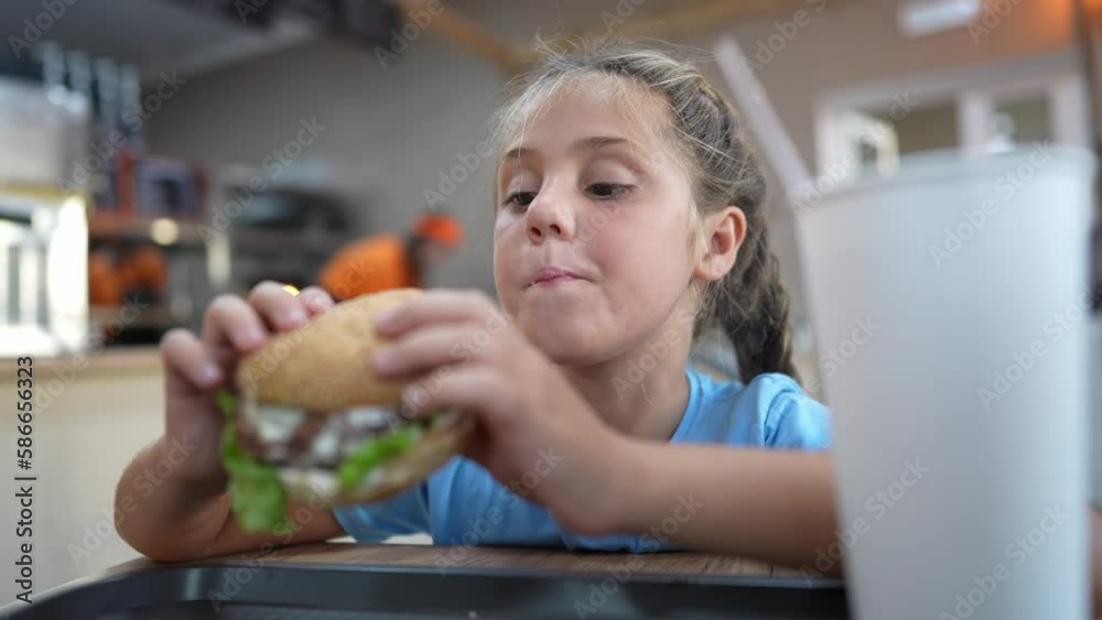 child kid eating a burger in a cafe. fast food nutrition health concept ...