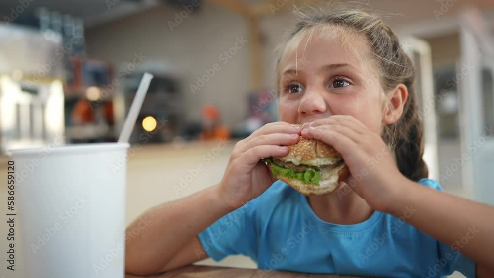 child kid eating a burger in a cafe. fast food nutrition health concept ...