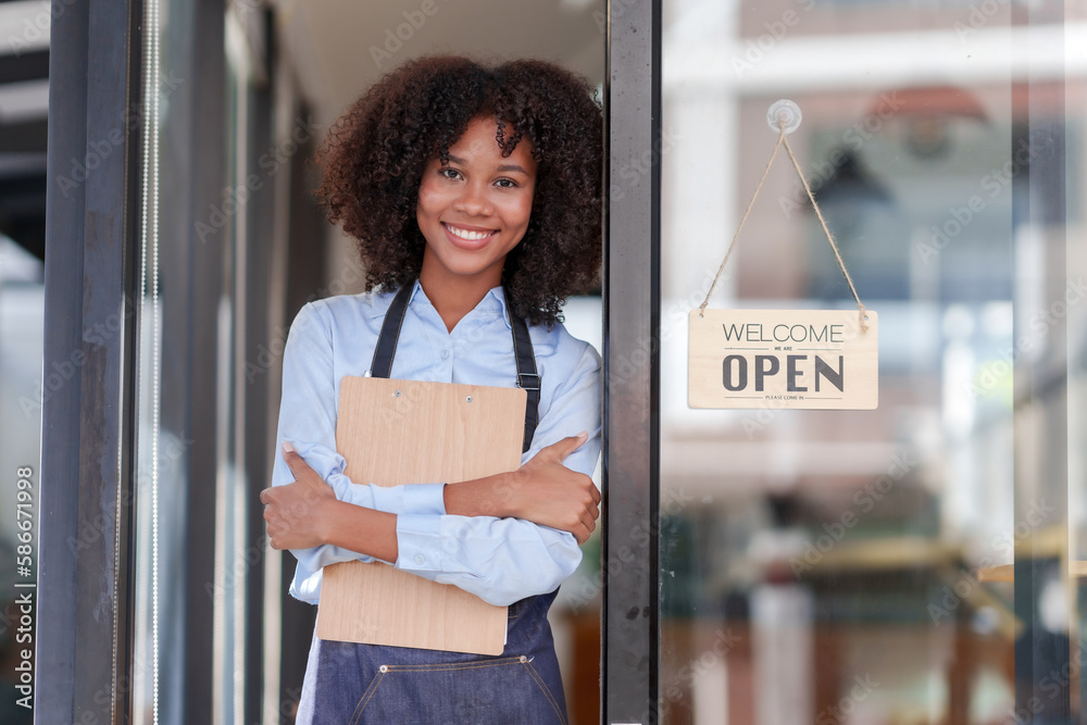 Female store owner or staff, food, cafe or bar, showing the OPEN sign ...