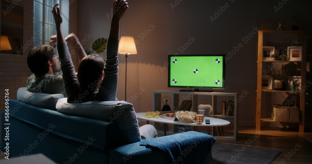 Emotional sports fan couple spending time together watching chroma-key ...