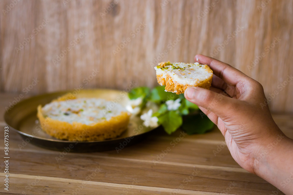 hand holding a piece of Ghewar or ghevar, which is a traditional sweet ...