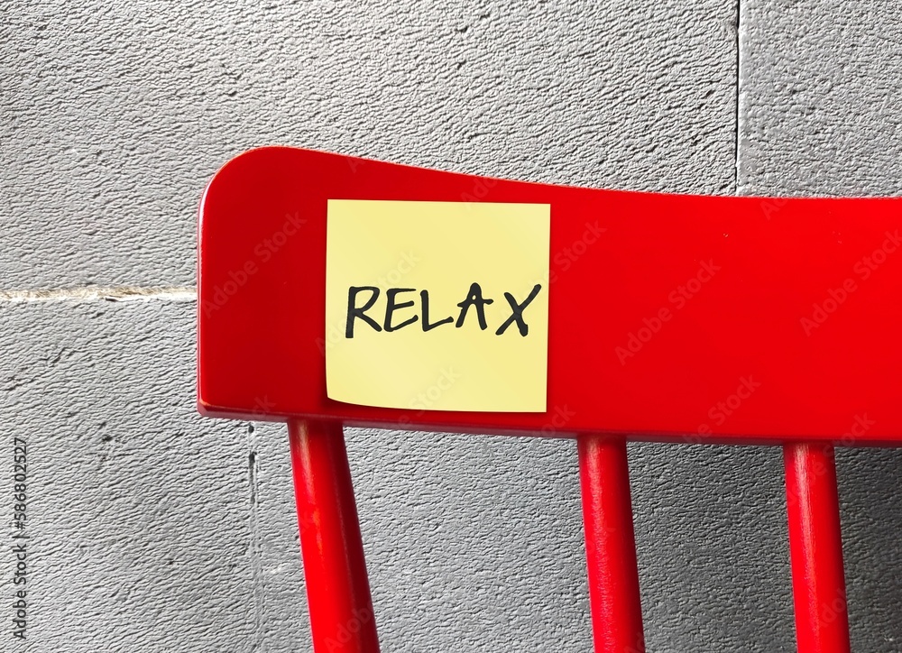 Stick note on red chair with handwritten text RELAX, reminder our ...
