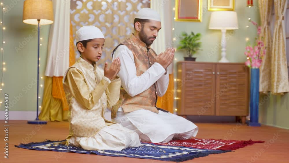 Indian Muslim father with kid doing namaz or praying during ramadan ...