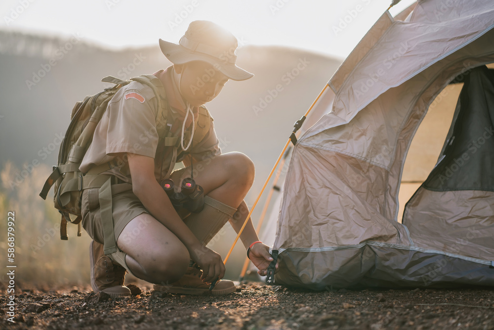 Asian male scouts pitch a tent during a nature education activity for ...