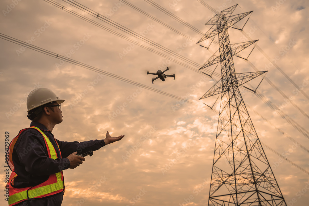 Asian electrical engineer wearing safety gear working near high voltage ...
