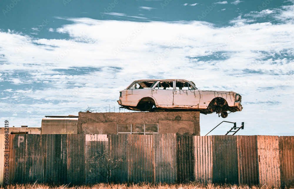 Discarded car placed on top of abandoned houses in the outback of South ...