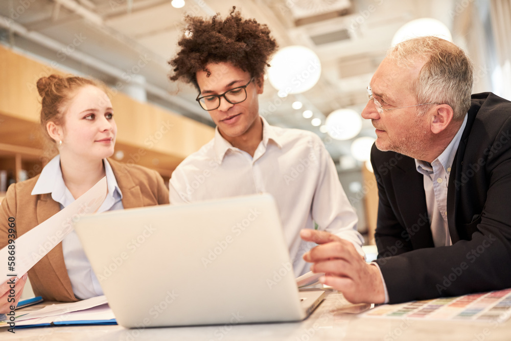 Start-up team planning a project on a laptop computer Stock Photo ...